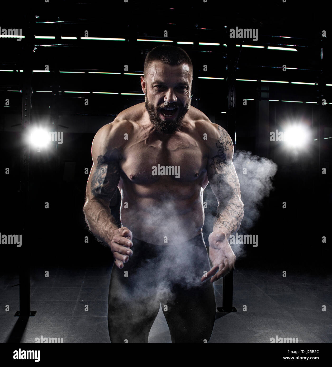 The portrait of muscular shirtless athlete clapping hands before the ...
