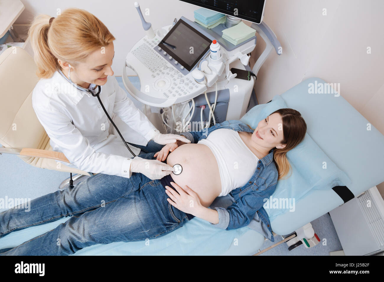 Upbeat obstetrician checking fetus viability in the clinic Stock Photo ...