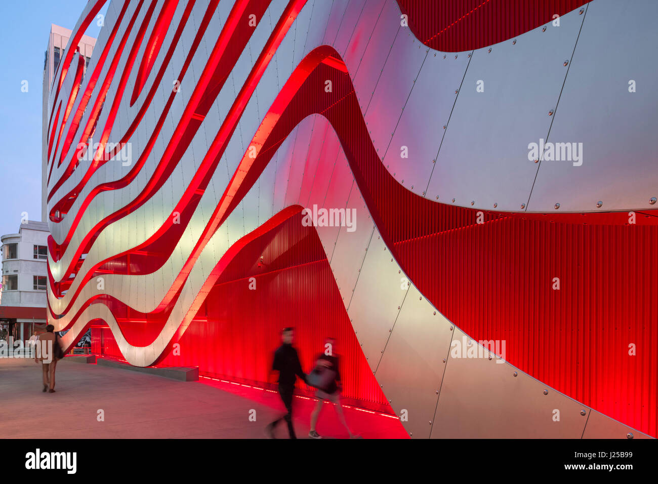 Details of steel ribbons in front illuminated rainscreen at dusk ...