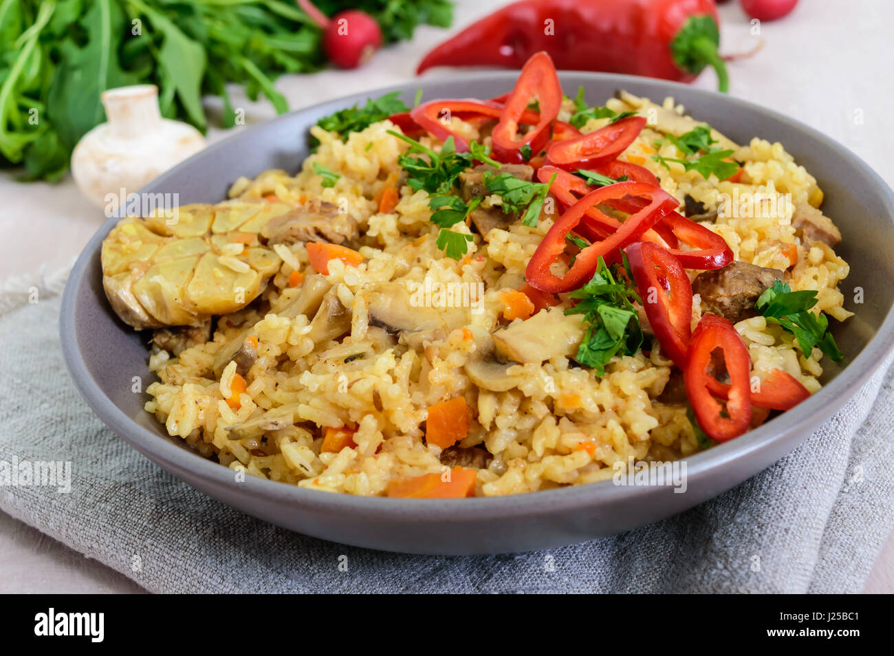 A traditional Asian dish - pilaf with meat, mushrooms and pepper capi ...