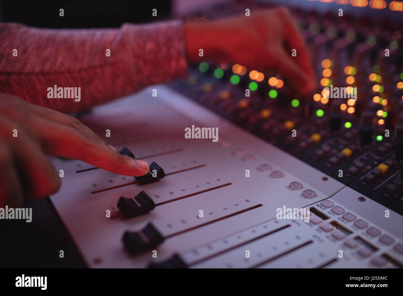 Hands of male audio engineer using sound mixer in recording studio ...