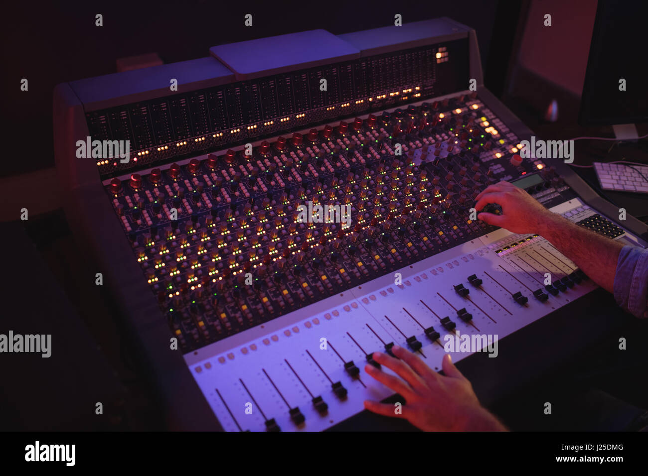 Hands of male audio engineer using sound mixer in recording studio ...