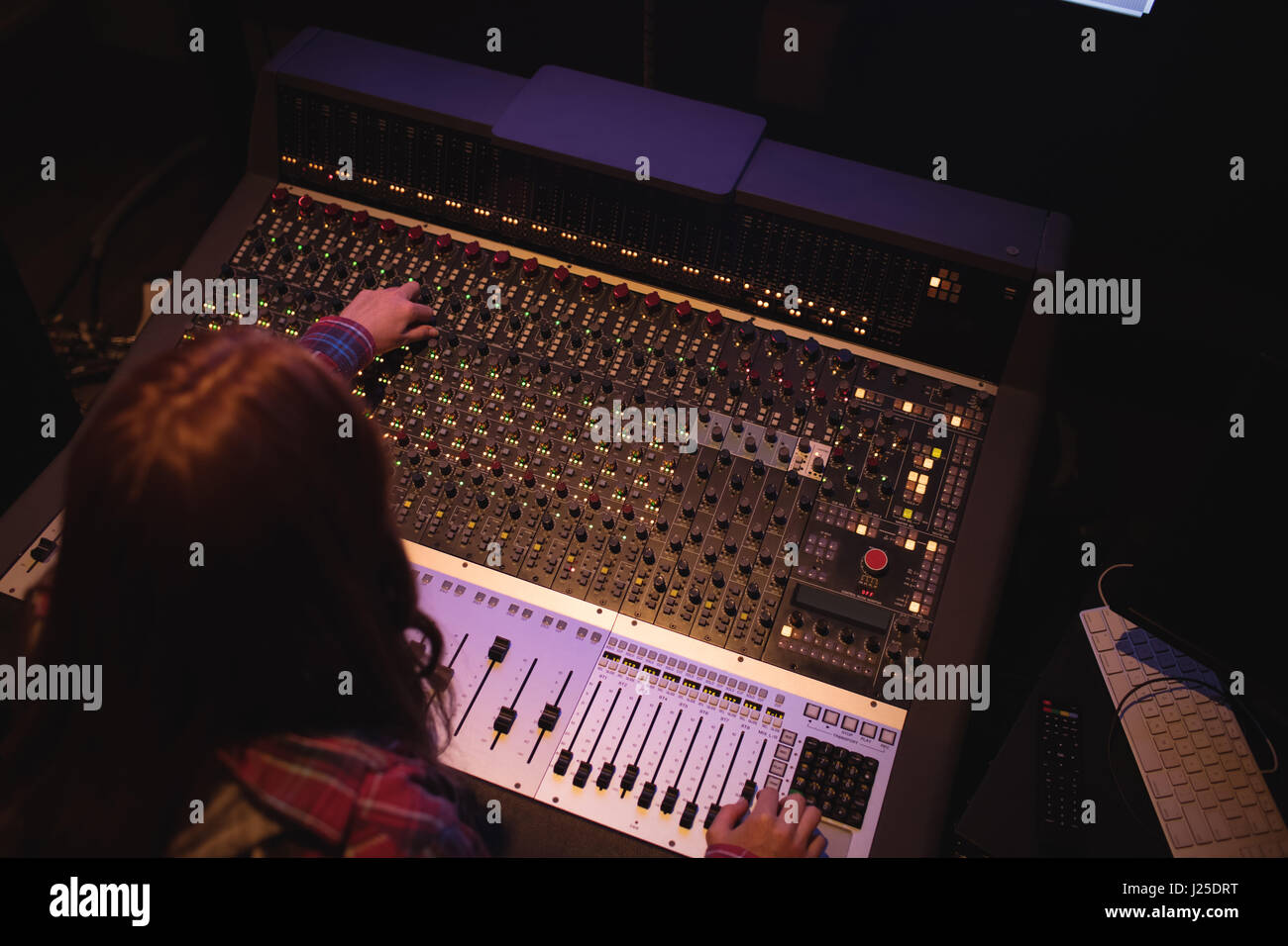 Female audio engineer using sound mixer in recording studio Stock Photo ...
