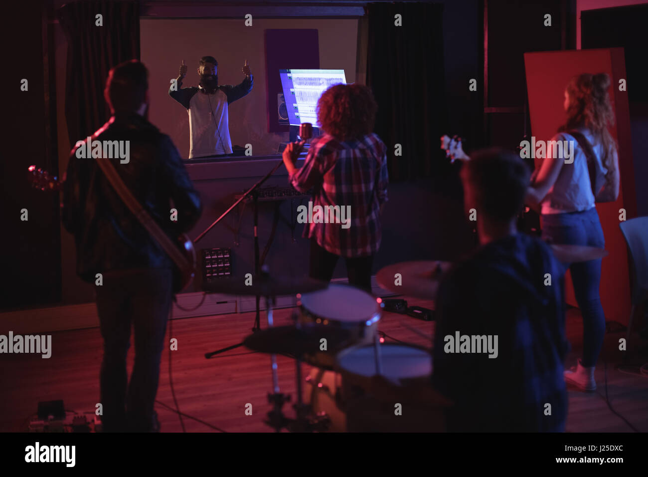 Rear view of band performing in recording studio Stock Photo - Alamy