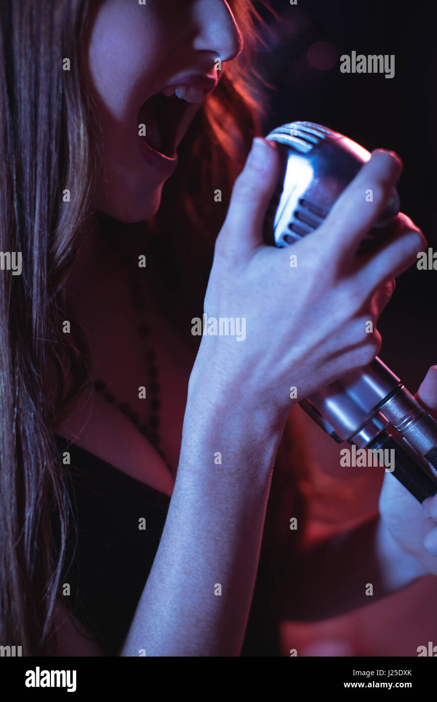 Close-up of female singer singing in recording studio Stock Photo - Alamy