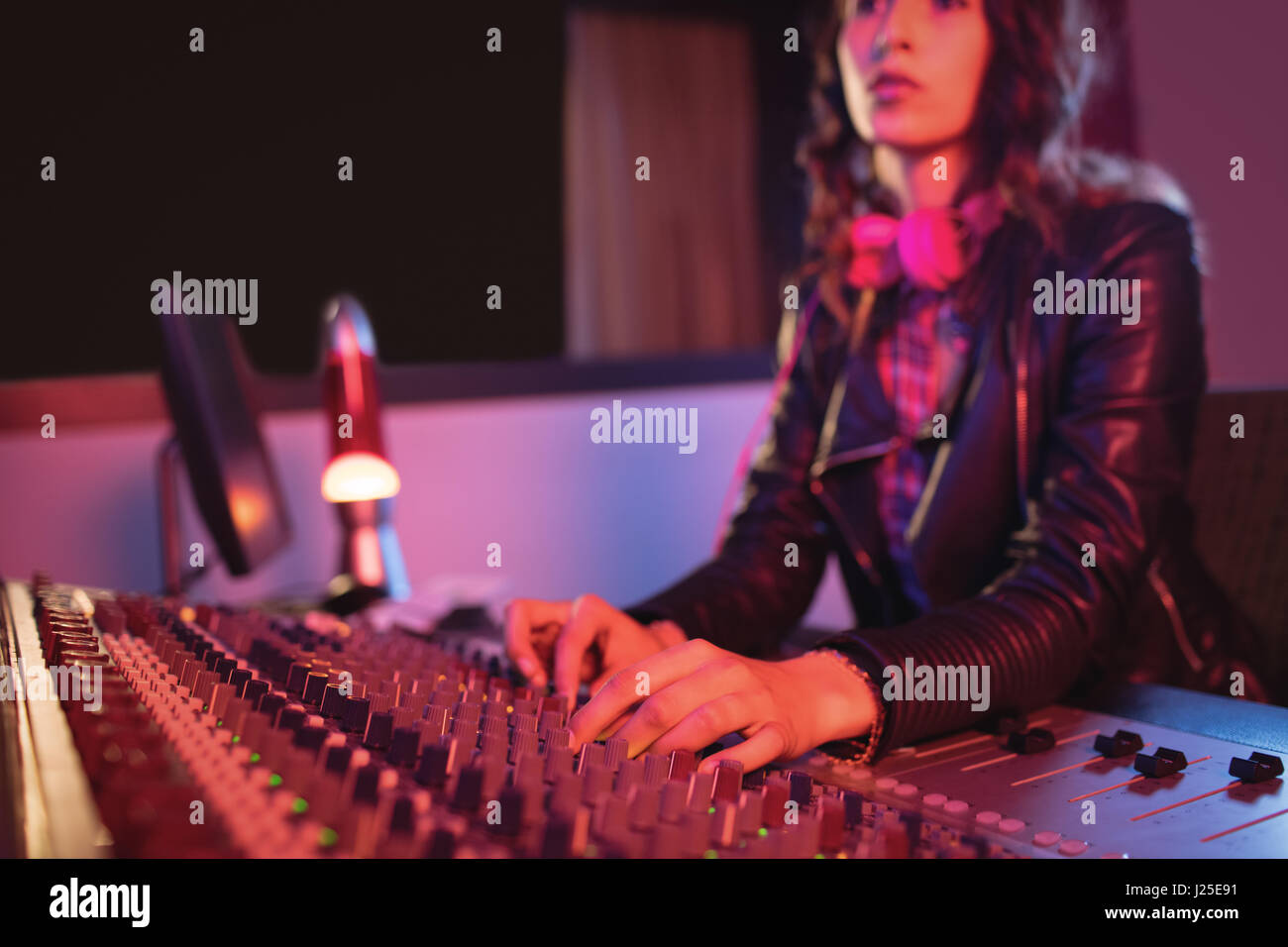 Female audio engineer using sound mixer in recording studio Stock Photo ...