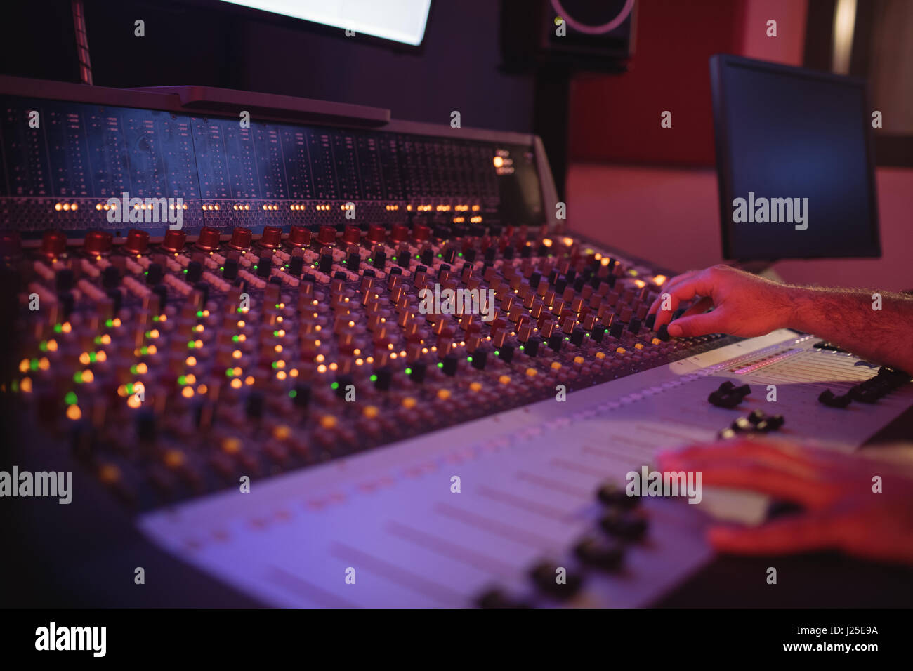 Hands of male audio engineer using sound mixer in recording studio ...
