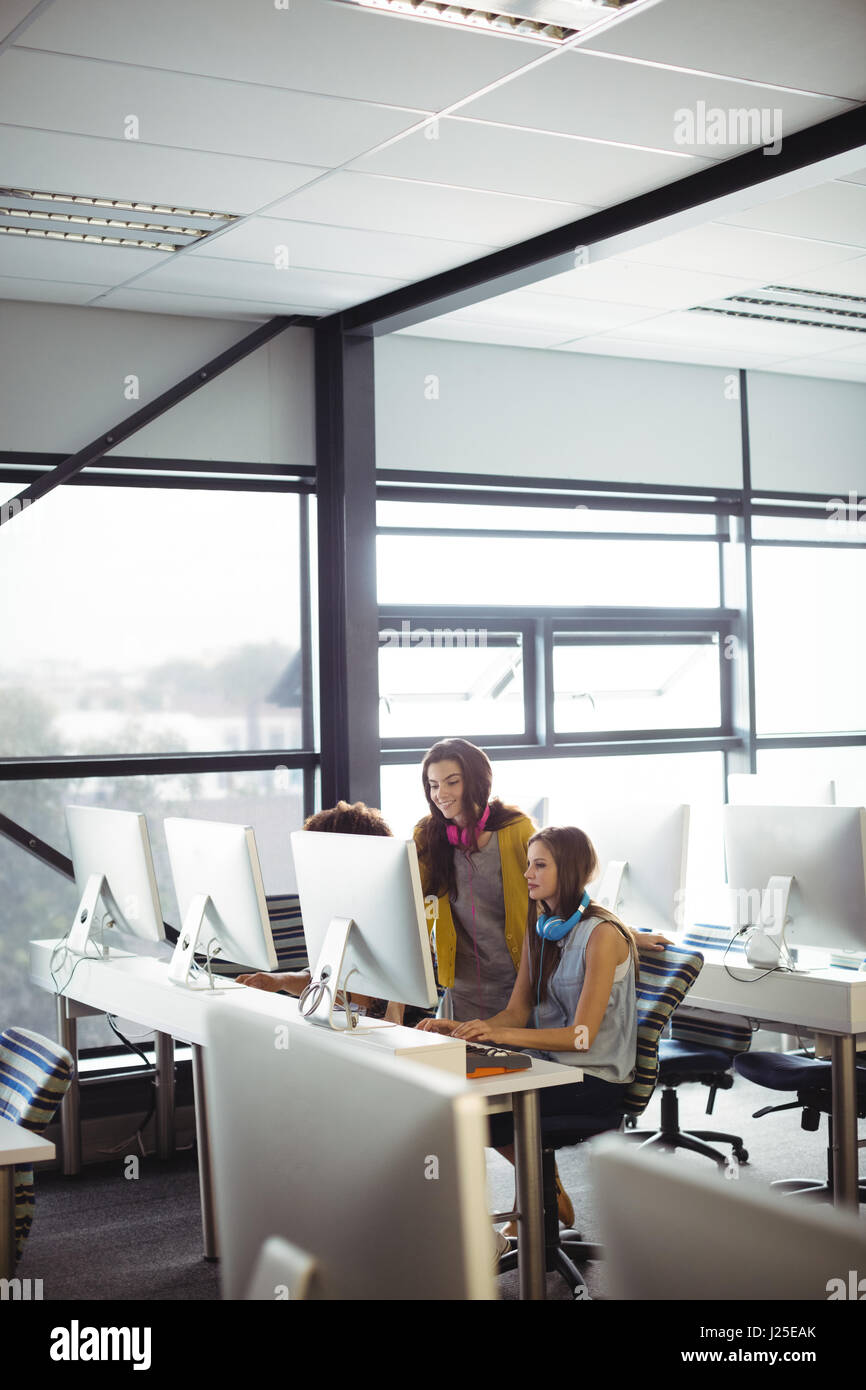 Attentive female sound engineer and colleague working in office Stock ...