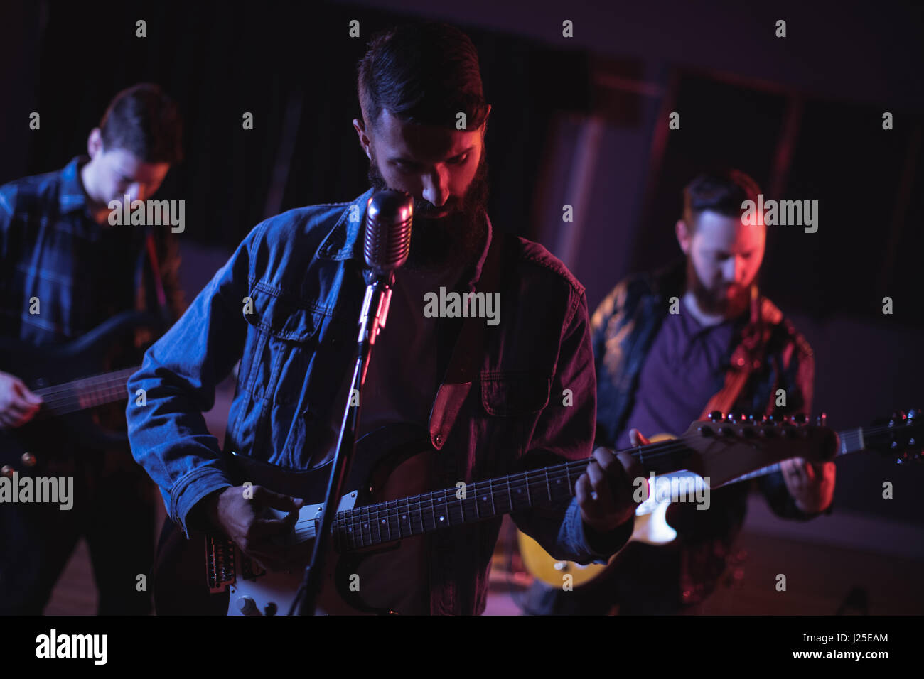 Band mates performing together in recording studio Stock Photo - Alamy