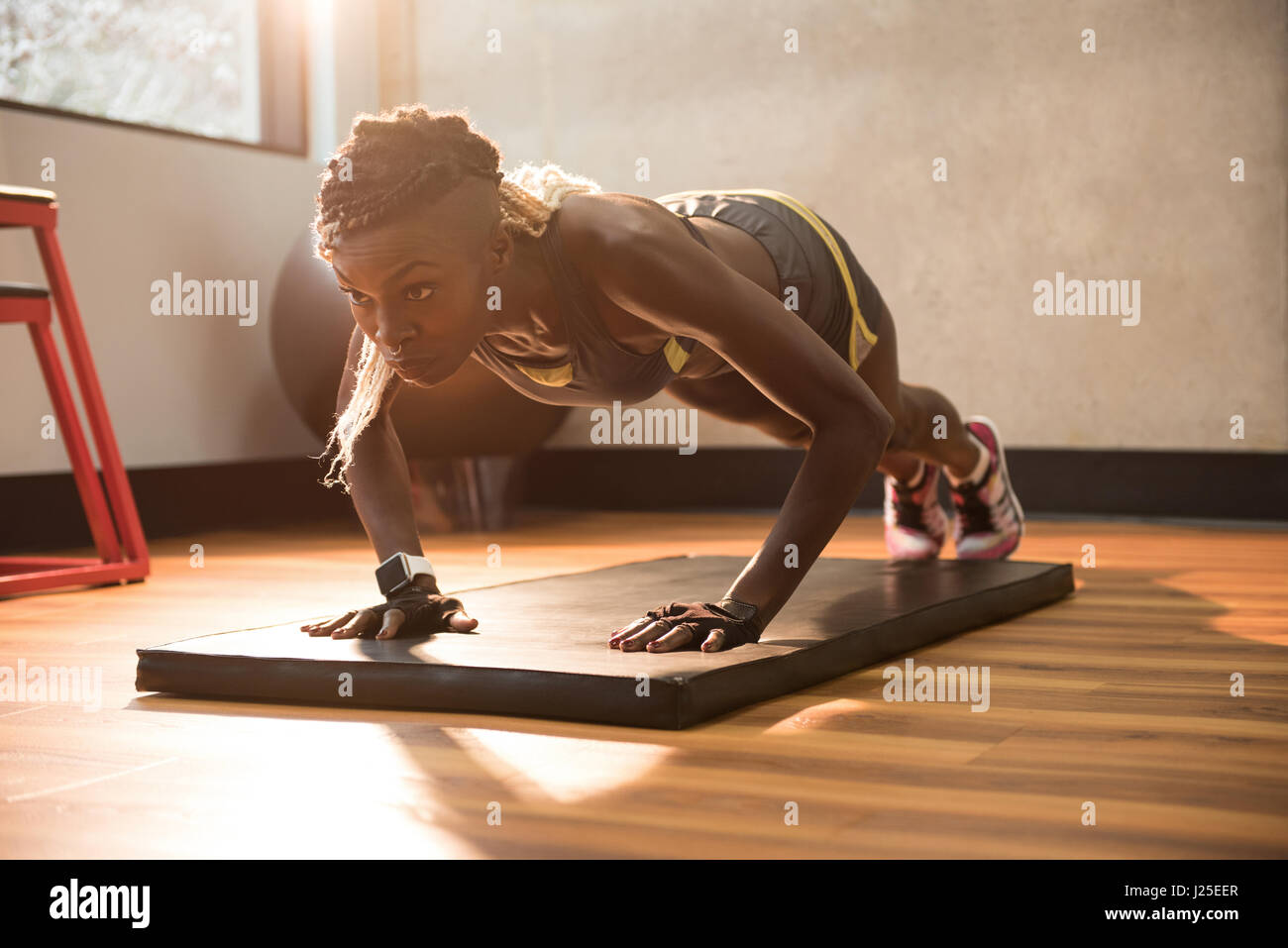 Fit woman performing push-up exercise on gymnastic mat in the gym Stock ...