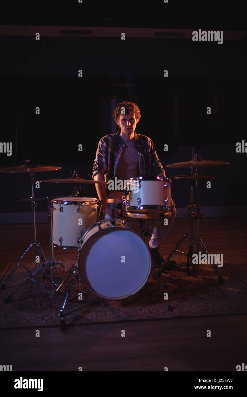 Portrait of drummer sitting with drum set in recording studio Stock ...