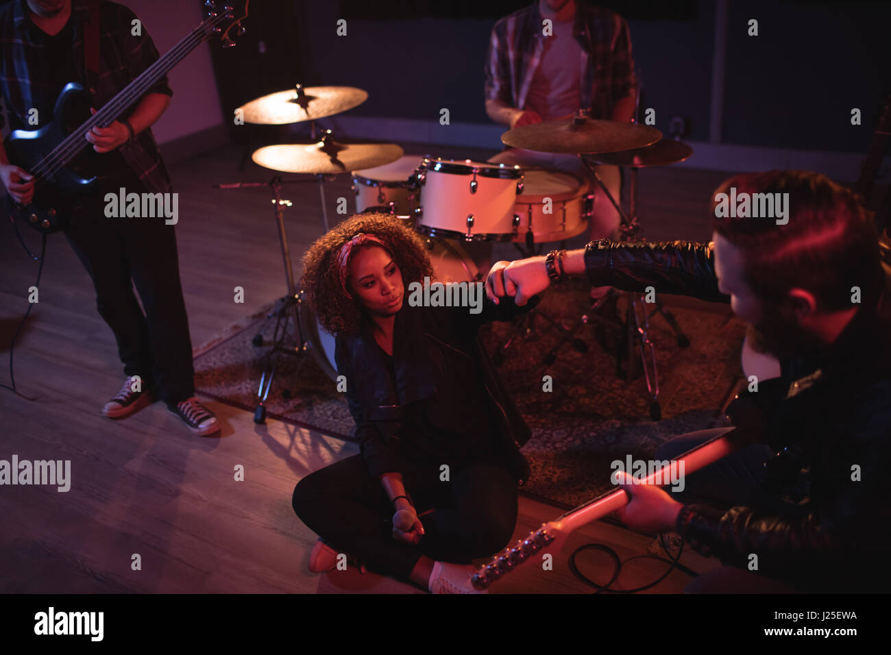 Band mates giving fist bump to each other in recording studio Stock ...