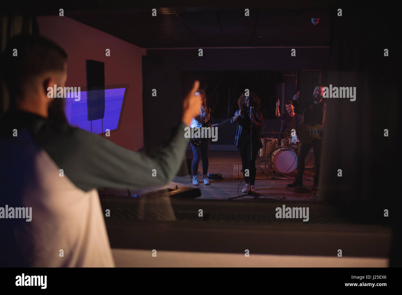 Music composer showing thumbs up in the studio Stock Photo - Alamy