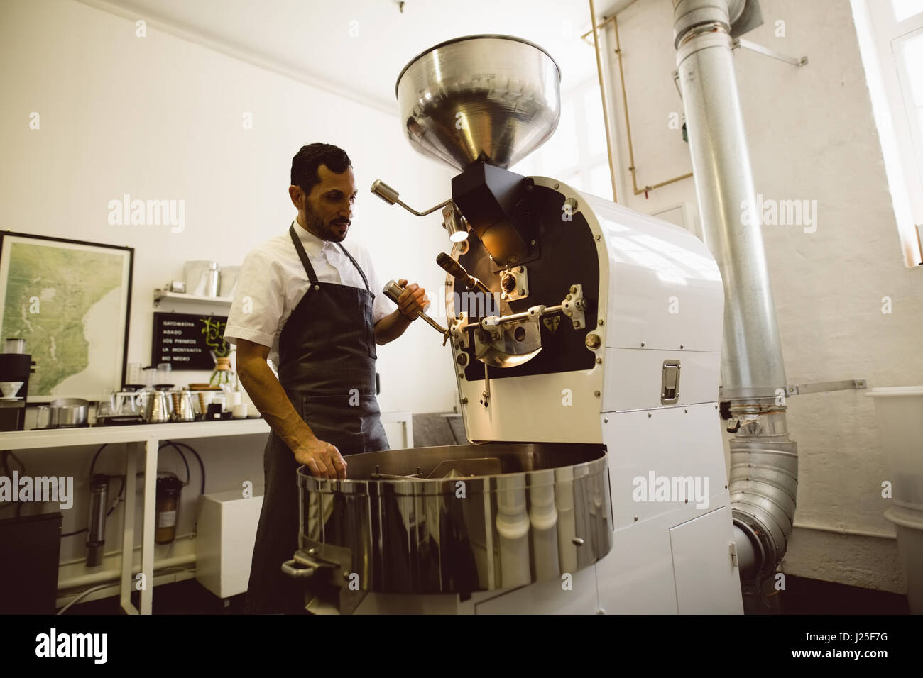 Man operating coffee roasting machine in coffee shop Stock Photo - Alamy