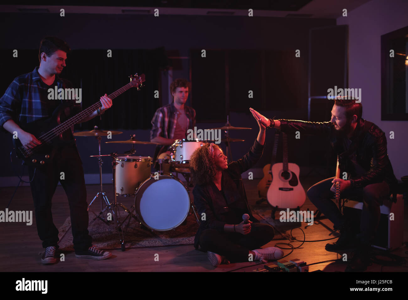 Band mates giving high five to each other in recording studio Stock ...