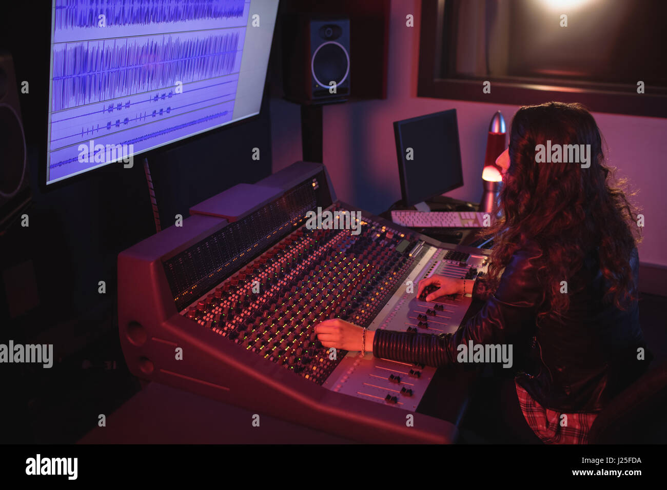 Female audio engineer using sound mixer in recording studio Stock Photo ...