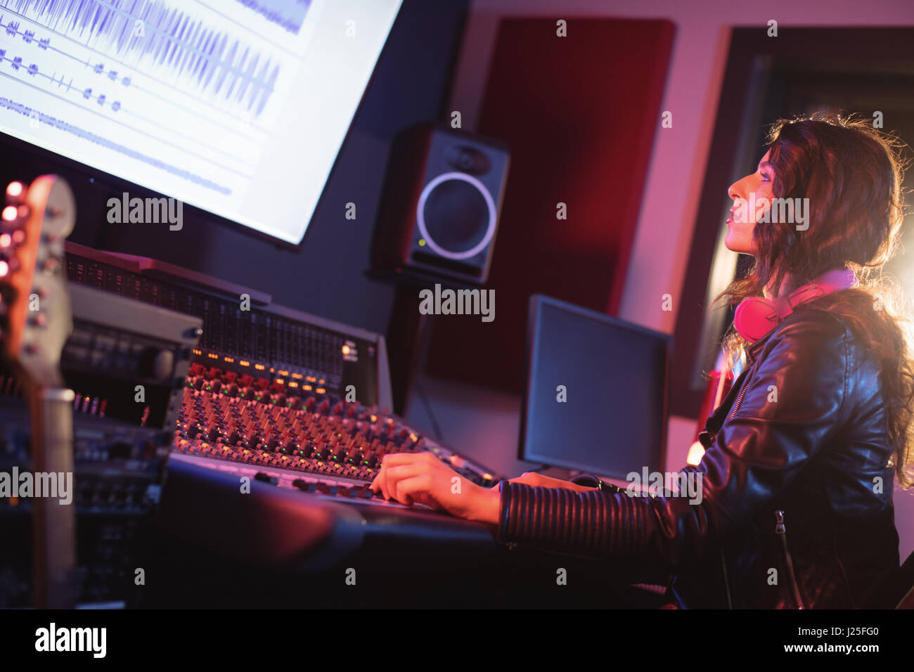 Female audio engineer using sound mixer in recording studio Stock Photo ...