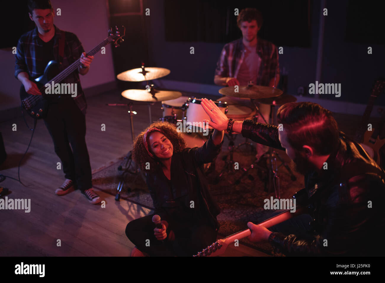 Band mates giving high five to each other in recording studio Stock ...
