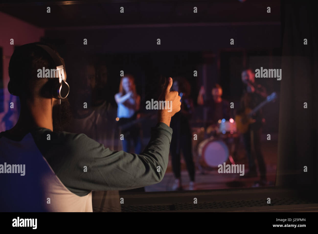Music composer showing thumbs up in the studio Stock Photo - Alamy