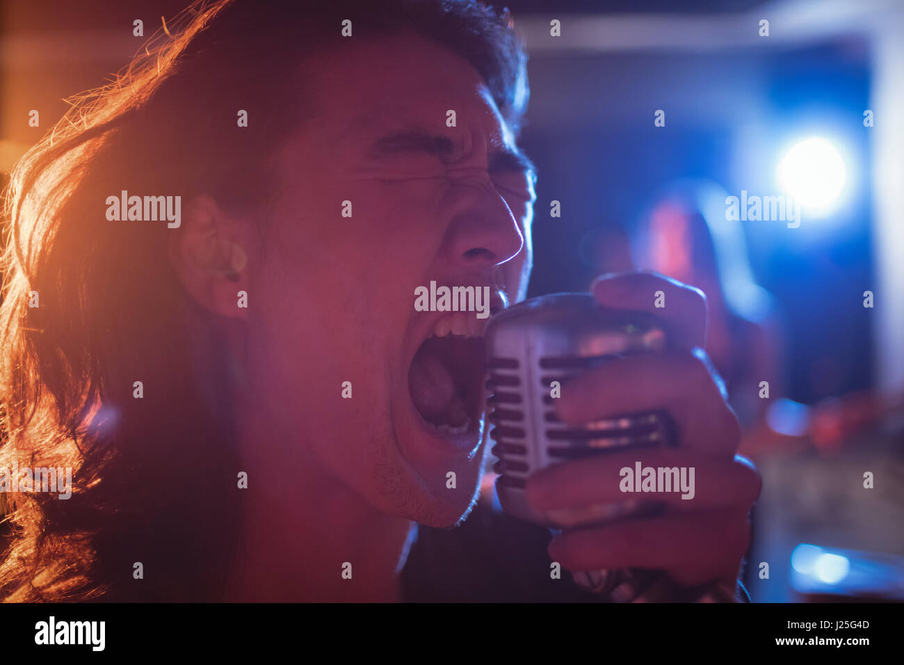 Close-up of male singer singing in recording studio Stock Photo - Alamy