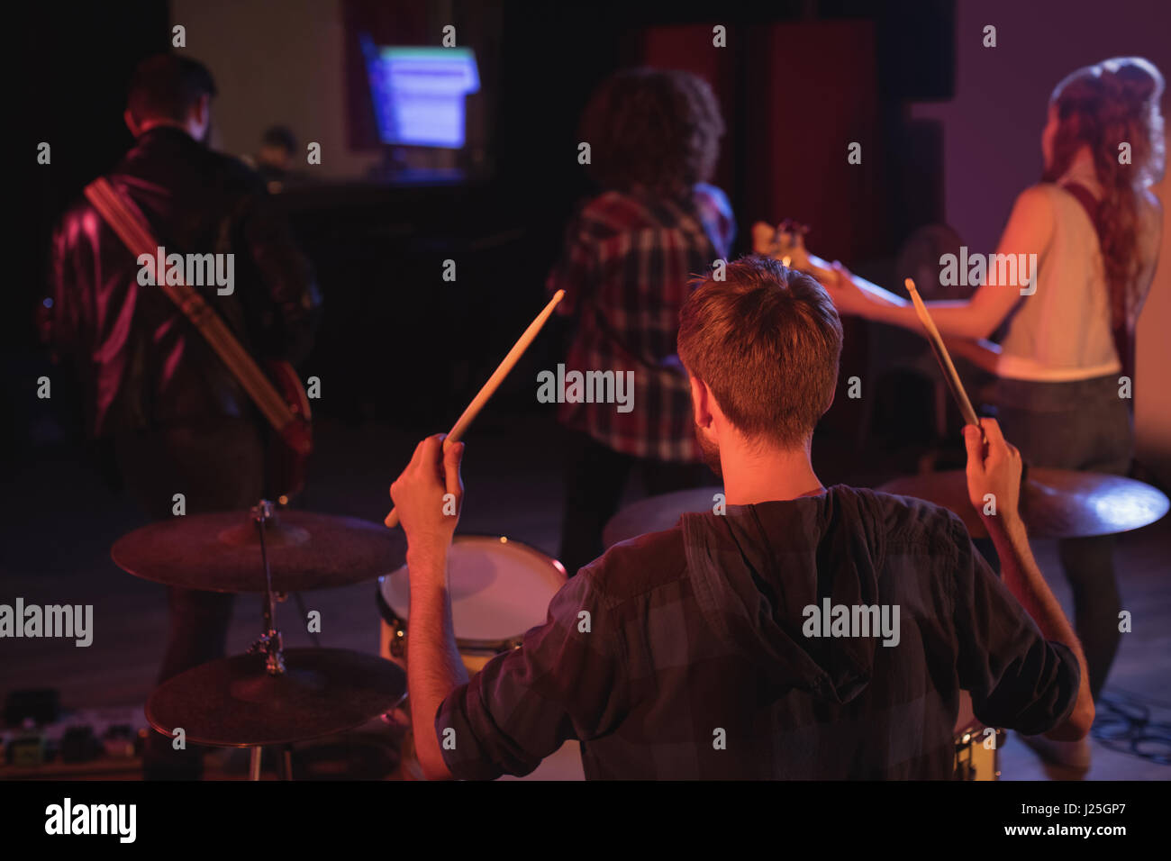 Rear view of band performing in recording studio Stock Photo - Alamy