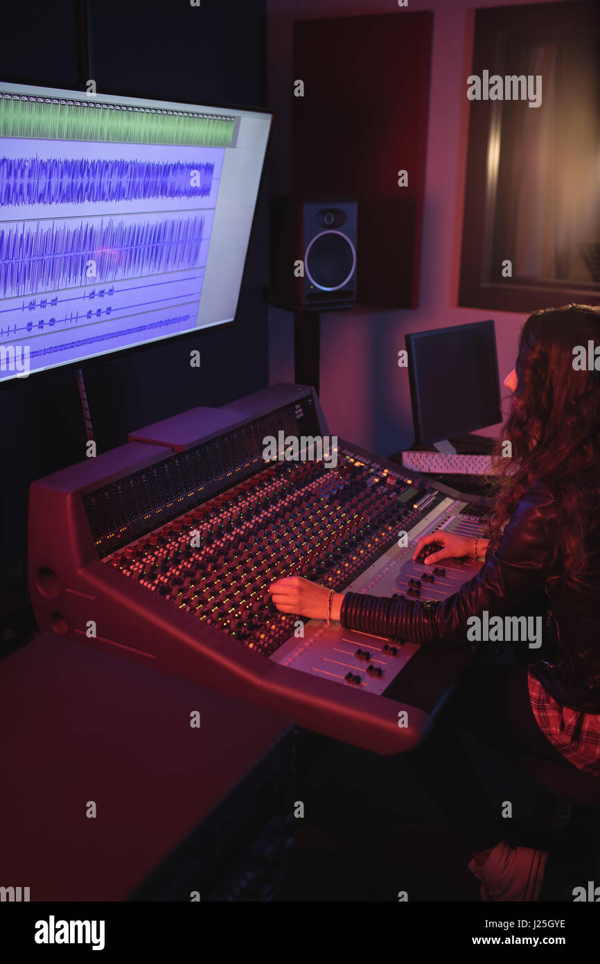 Female audio engineer using sound mixer in recording studio Stock Photo ...