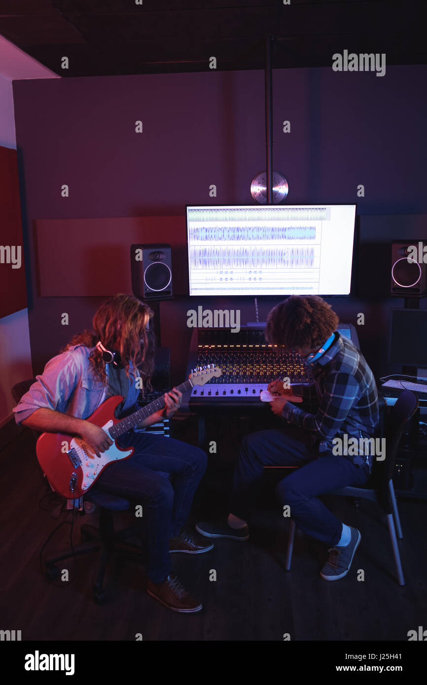 Male audio engineers working together in recording studio Stock Photo ...