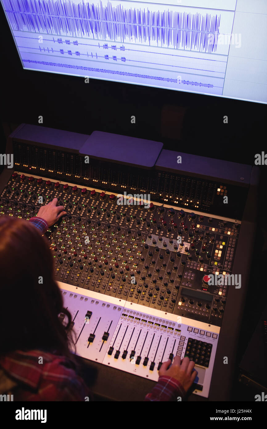 Female audio engineer using sound mixer in recording studio Stock Photo ...