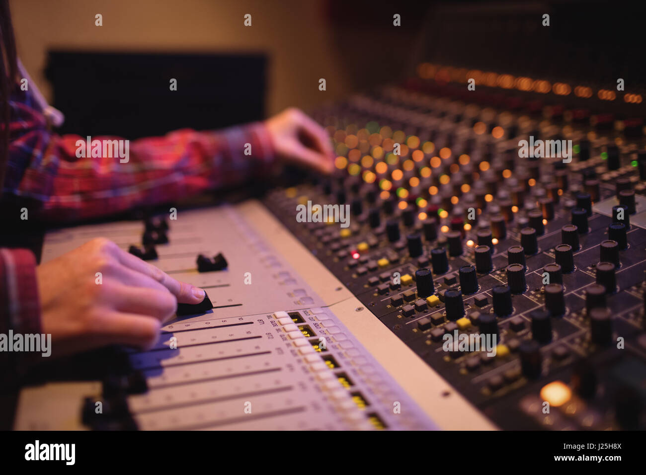Hands of female audio engineer using sound mixer in recording studio ...