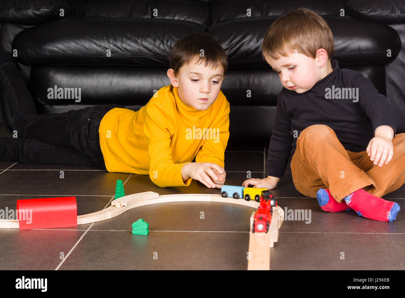 Children playing with wooden toy train. Brothers build wooden railroad ...