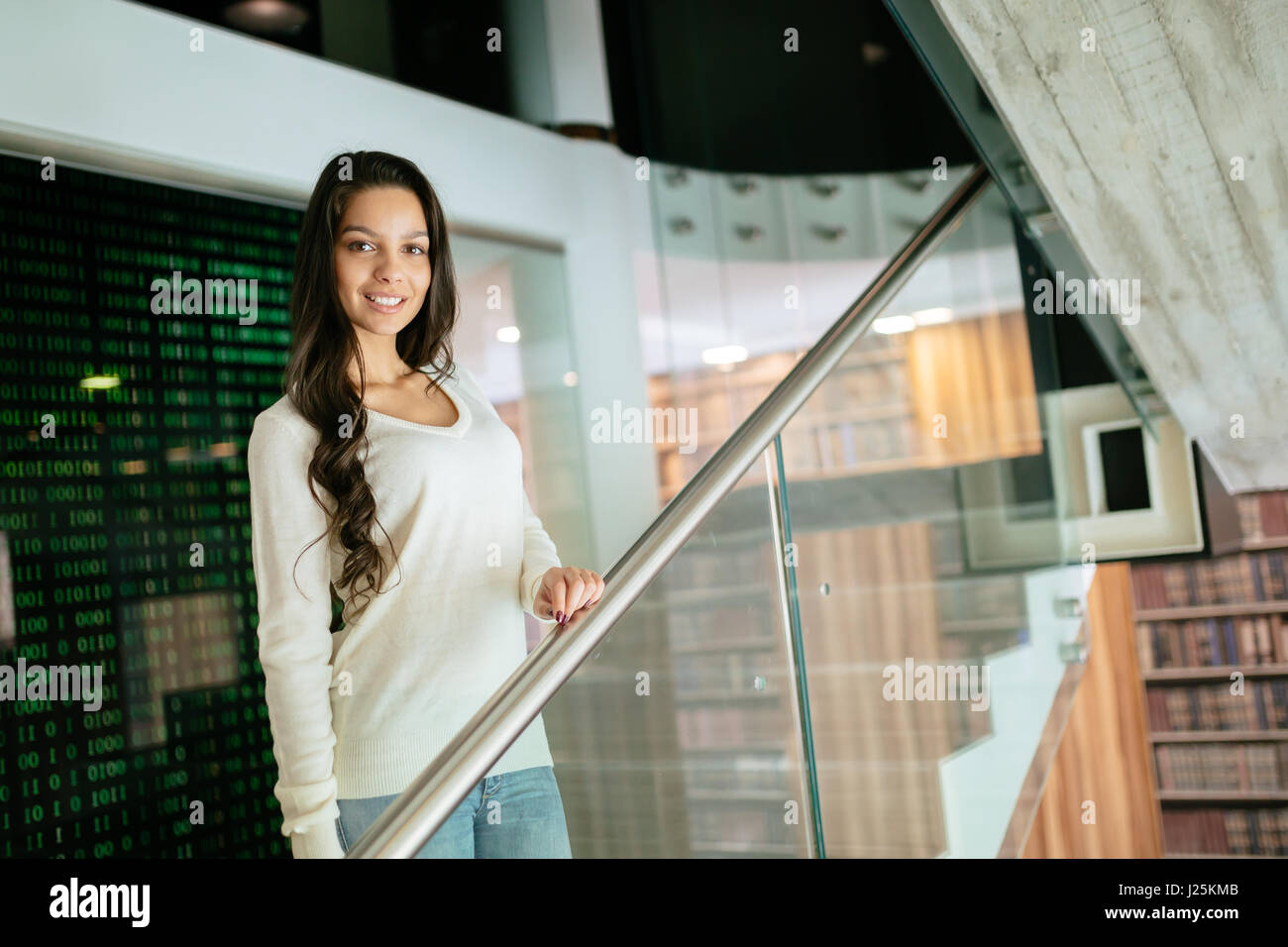 Beautiful brunette posing in library Stock Photo - Alamy