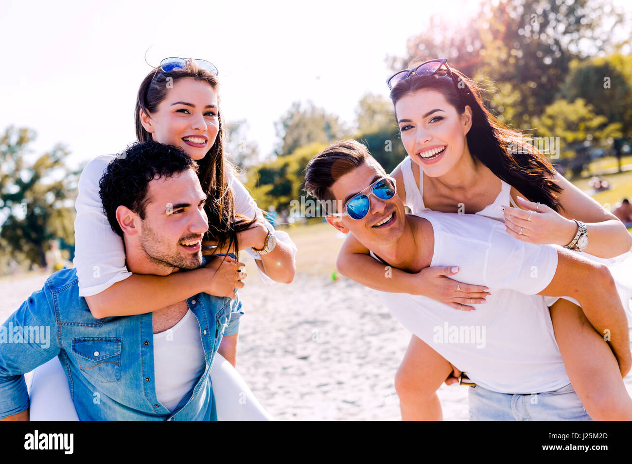 Woman carrying friend on beach hi-res stock photography and images - Alamy