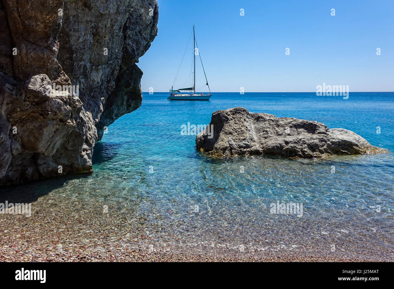 Yacht moored by rocks off the Greek Island of Rhodes Stock Photo - Alamy