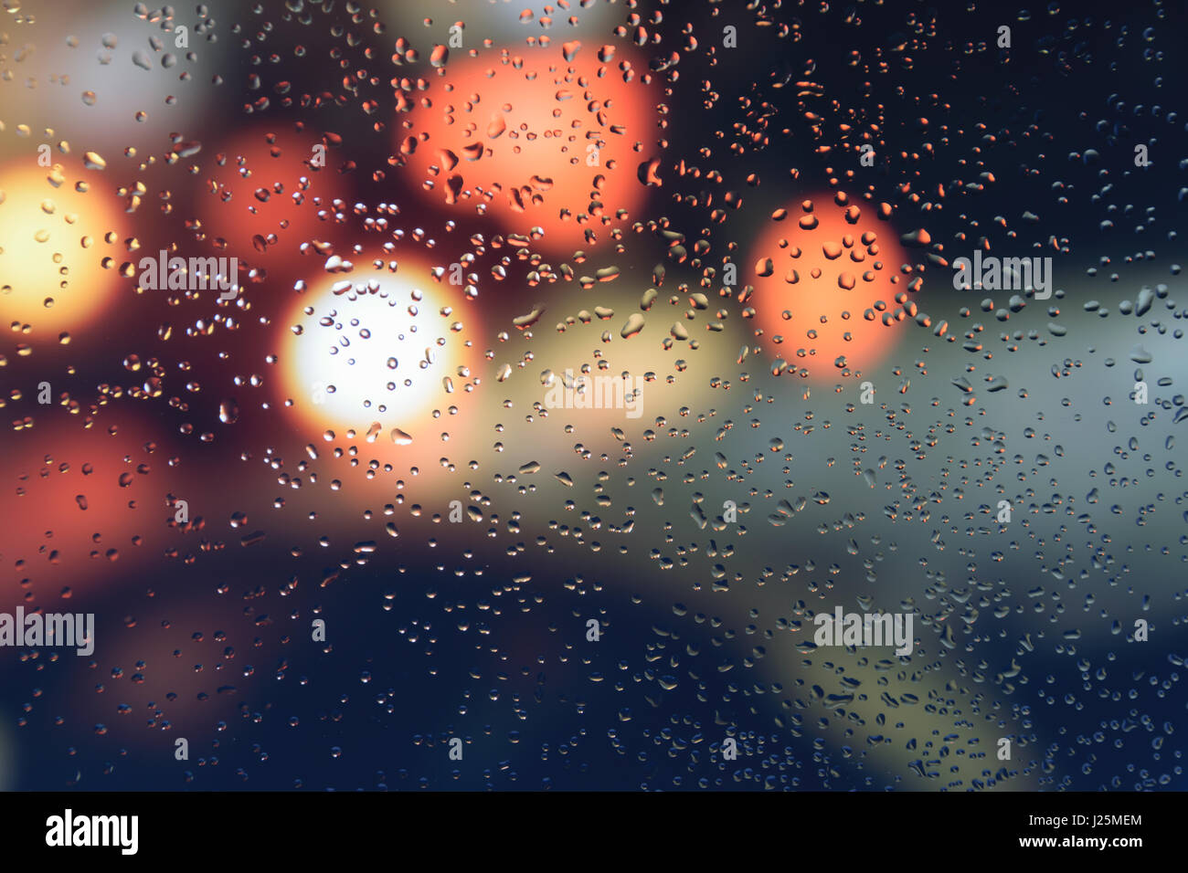 Raindrops on a car window with beautifully blurred background of street ...