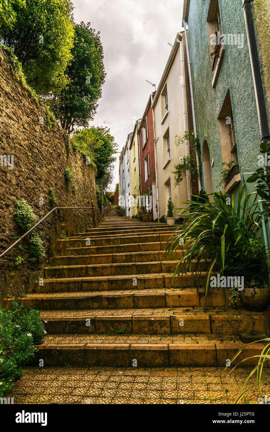 Colorful buildings along the stairs next to the stone wall, climbing up ...