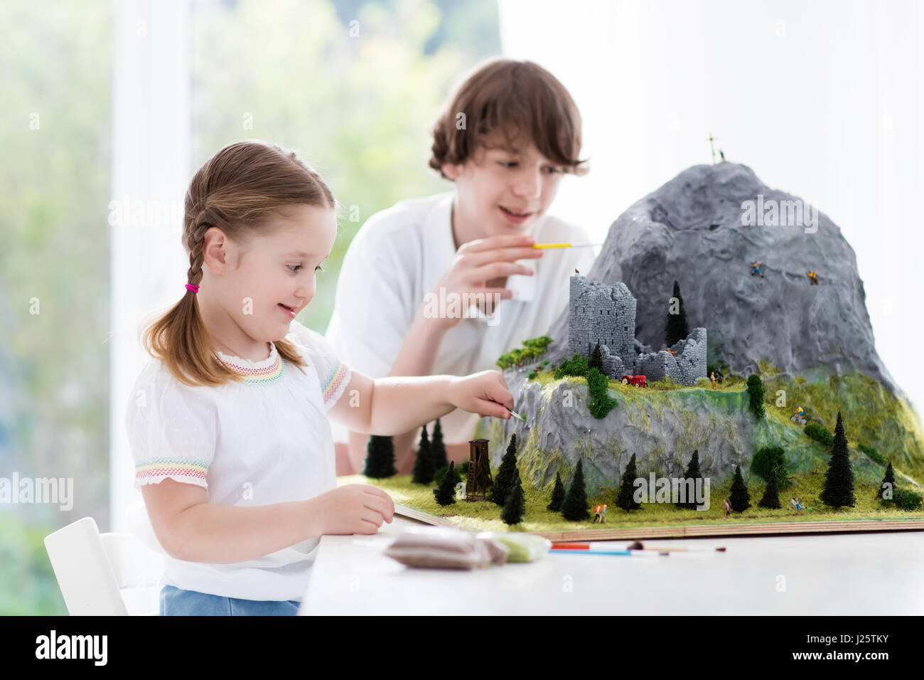 Children work on model building school project. Kids build miniature ...