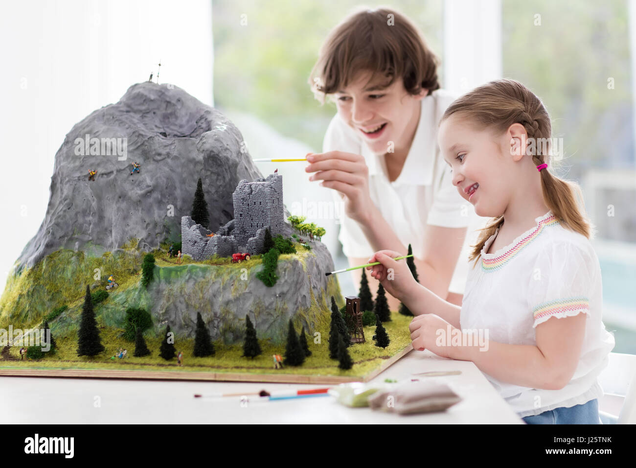 Children work on model building school project. Kids build miniature ...
