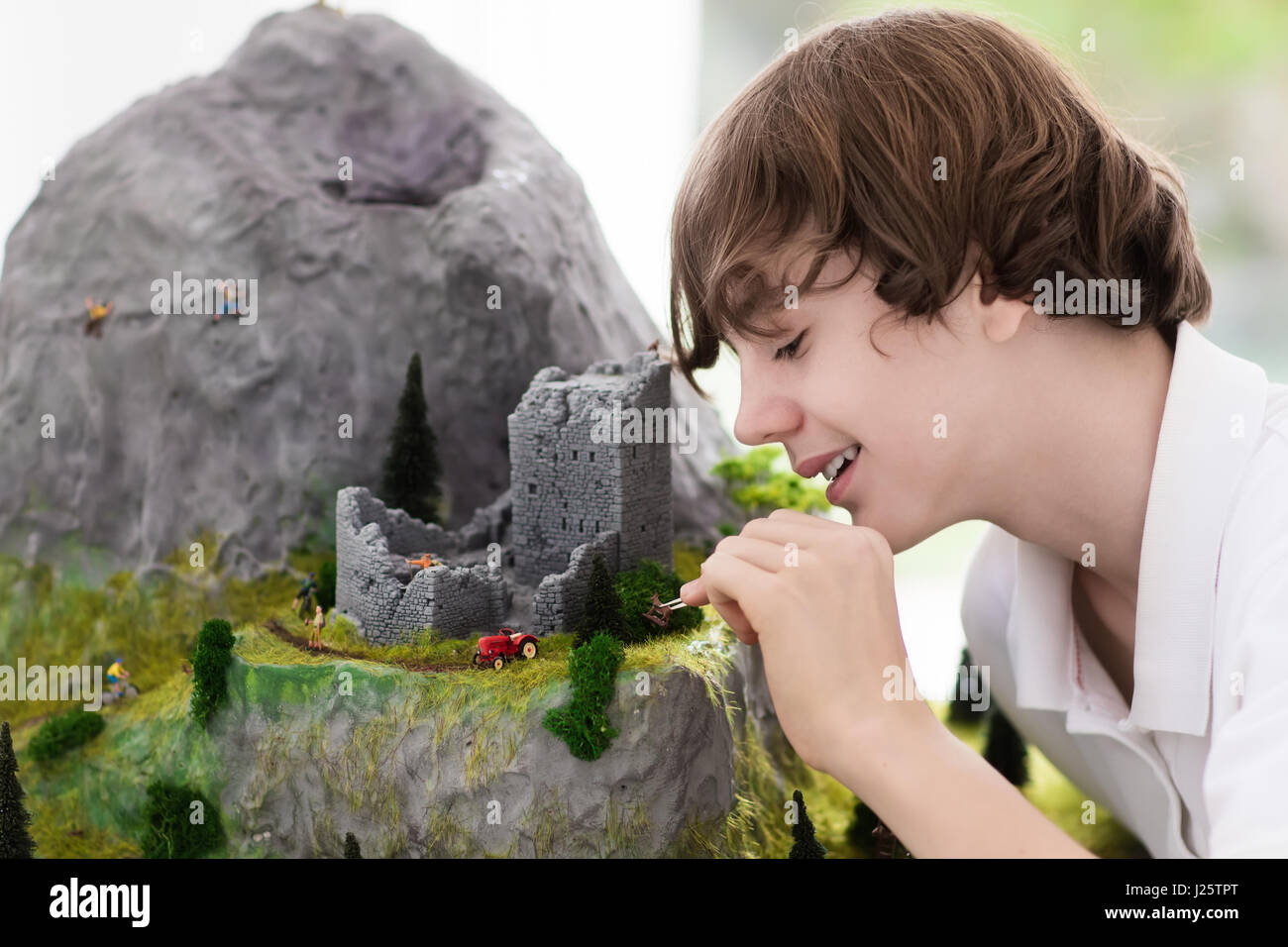 Teenager working on model building school project. Kids build miniature ...