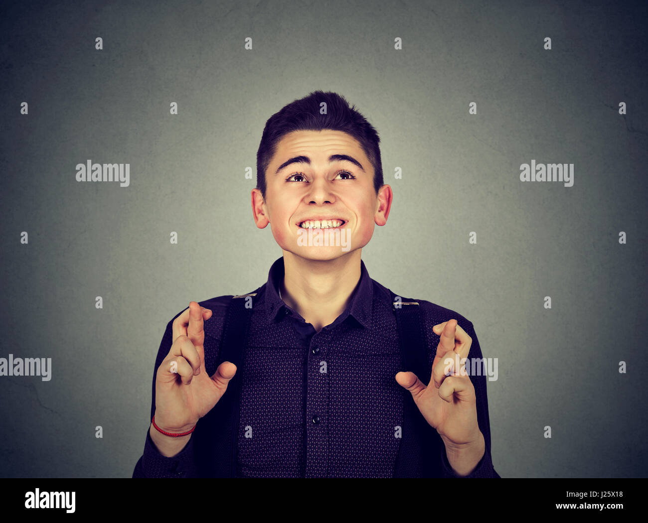 Young man making a wish keeping his fingers crossed. Body language ...