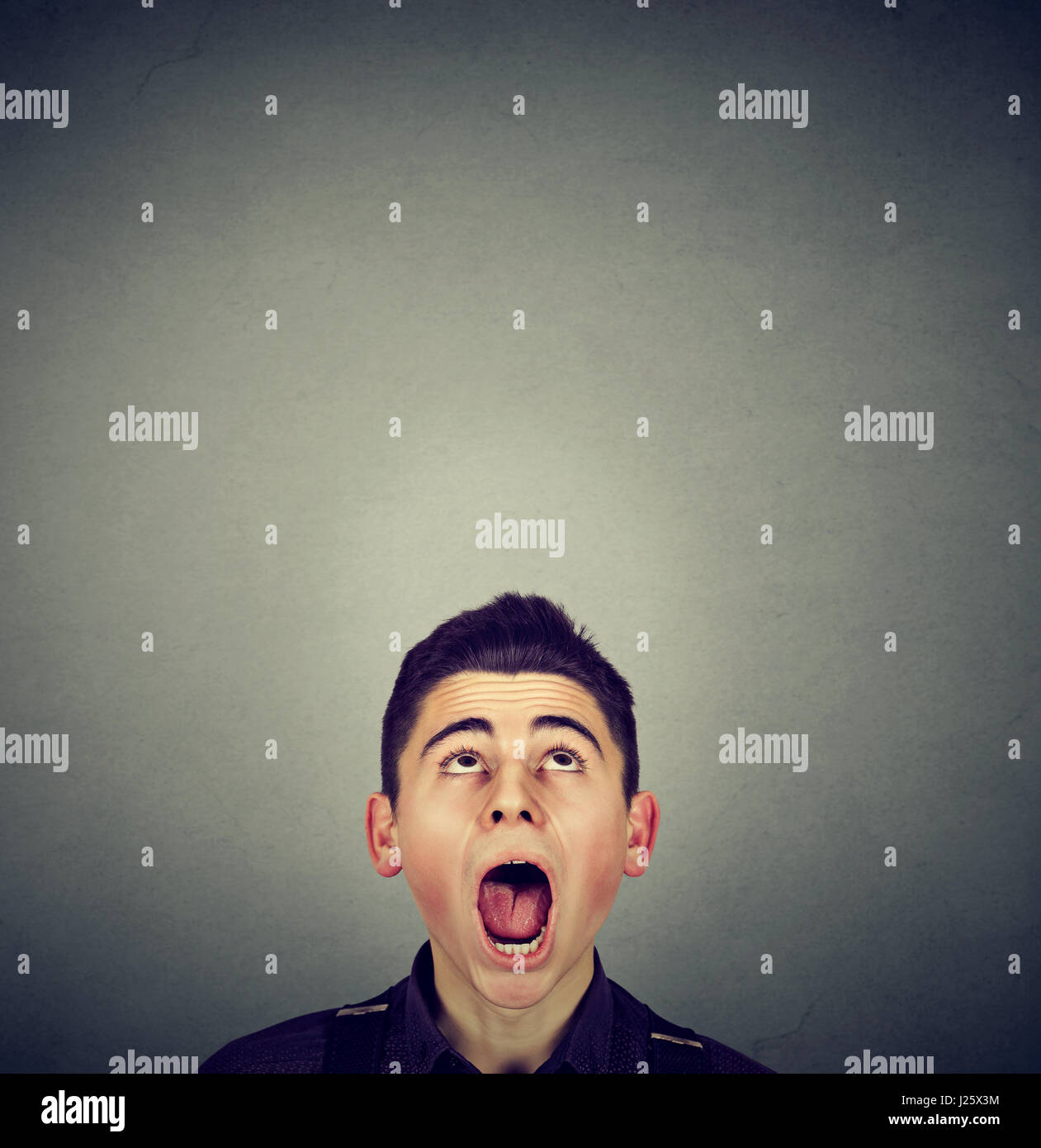 Surprised young man looking up Stock Photo - Alamy
