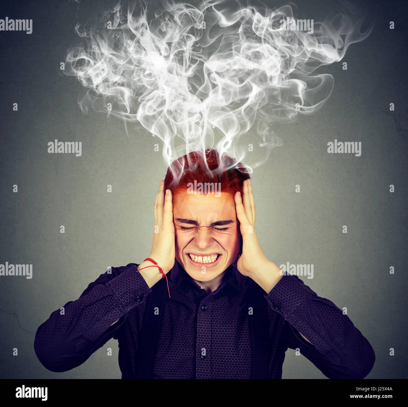 Stressed man thinks very intensely having headache isolated on gray ...