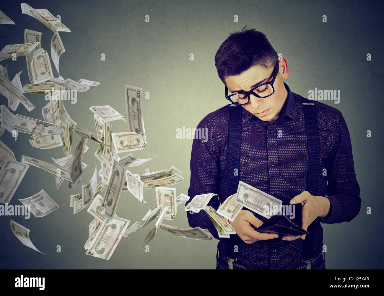 Sad man looking at his wallet with money dollar banknotes flying out ...