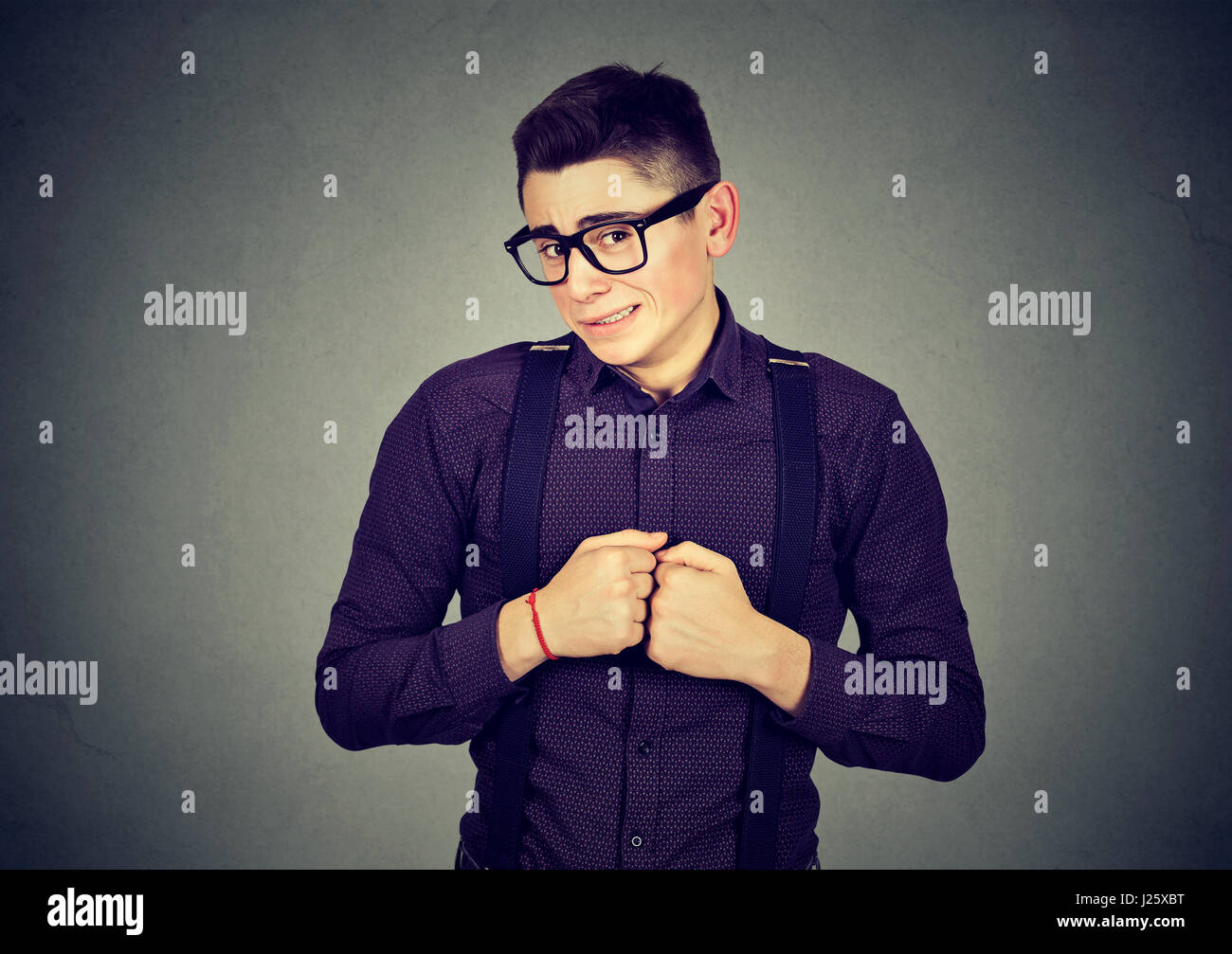 Portrait young man in unpleasant awkward situation playing nervously ...