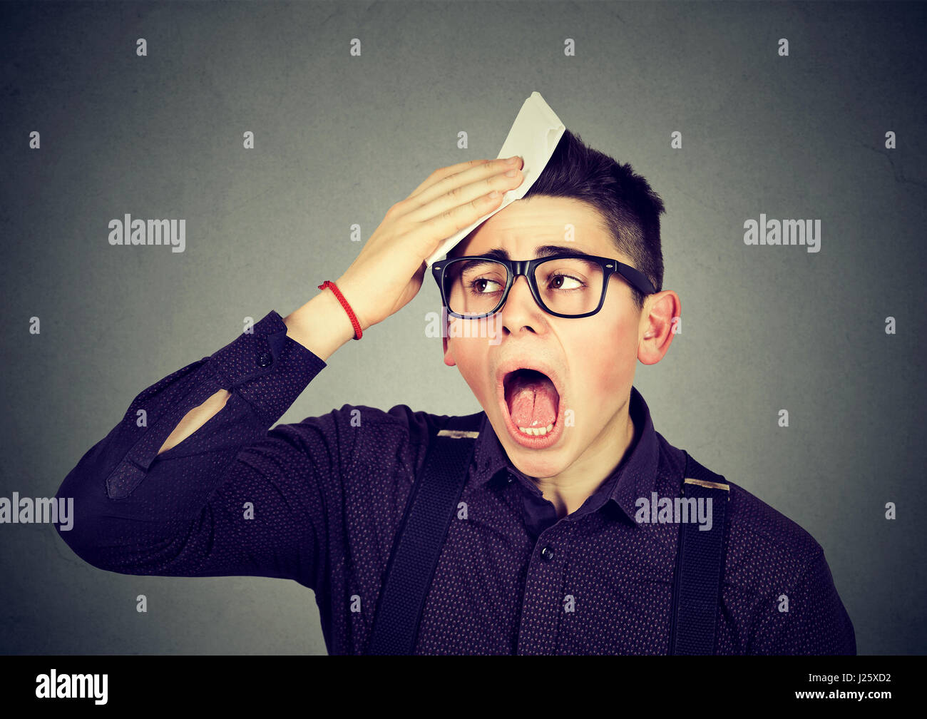 Tired man sweating isolated on gray background Stock Photo - Alamy
