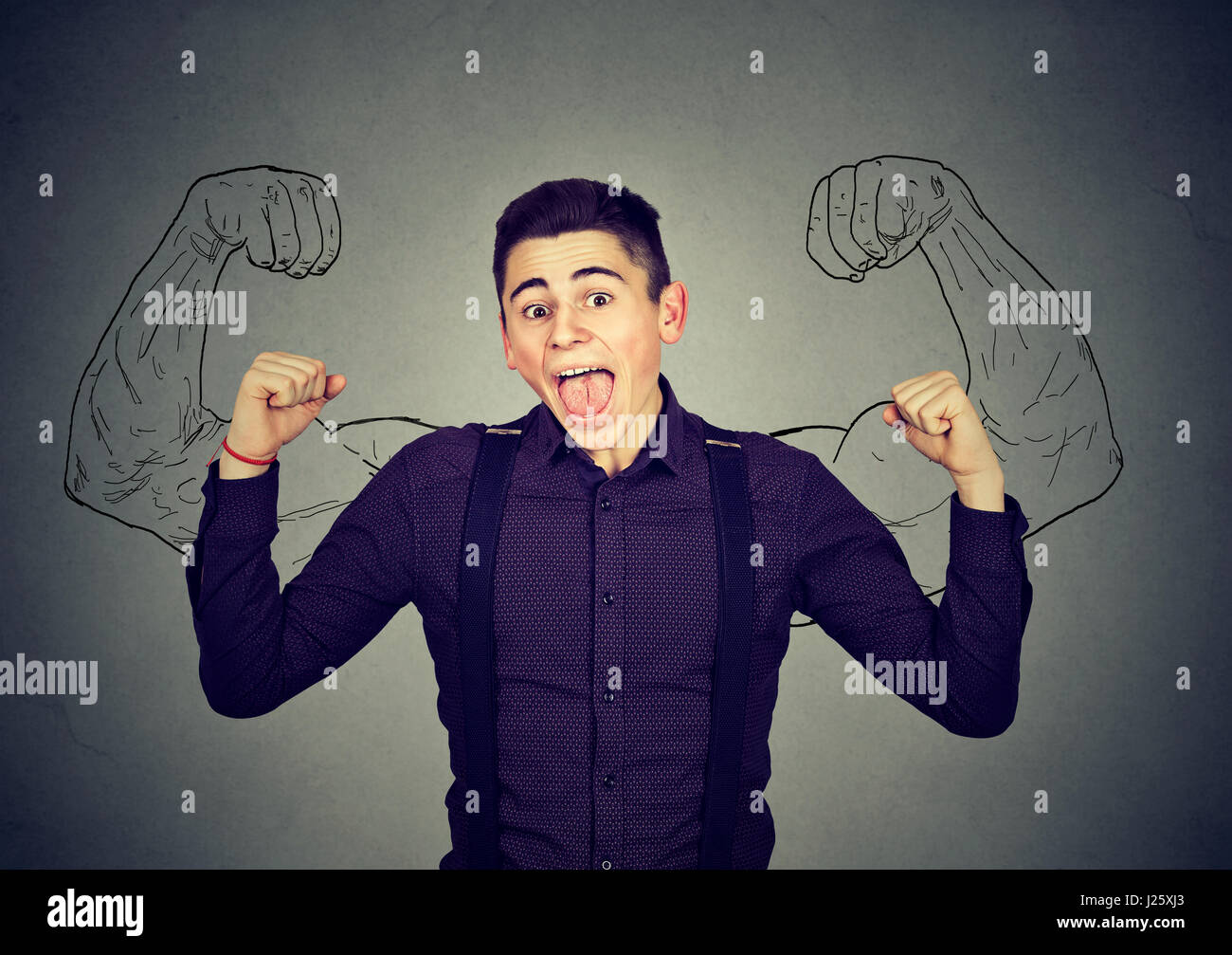 Powerful confident young man flexing his muscles isolated on gray wall ...