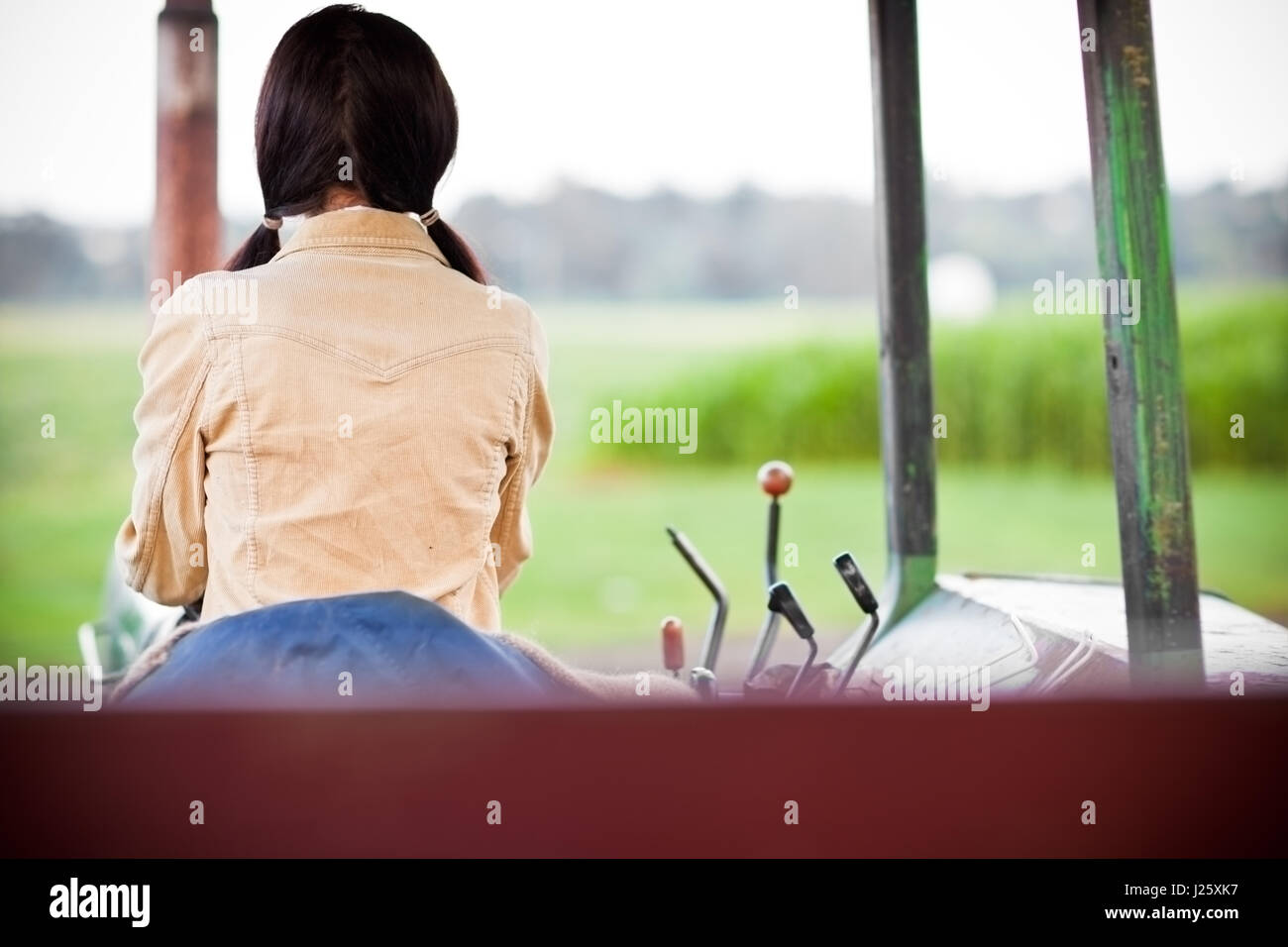 A shot of a girl riding a tractor in a farm Stock Photo - Alamy
