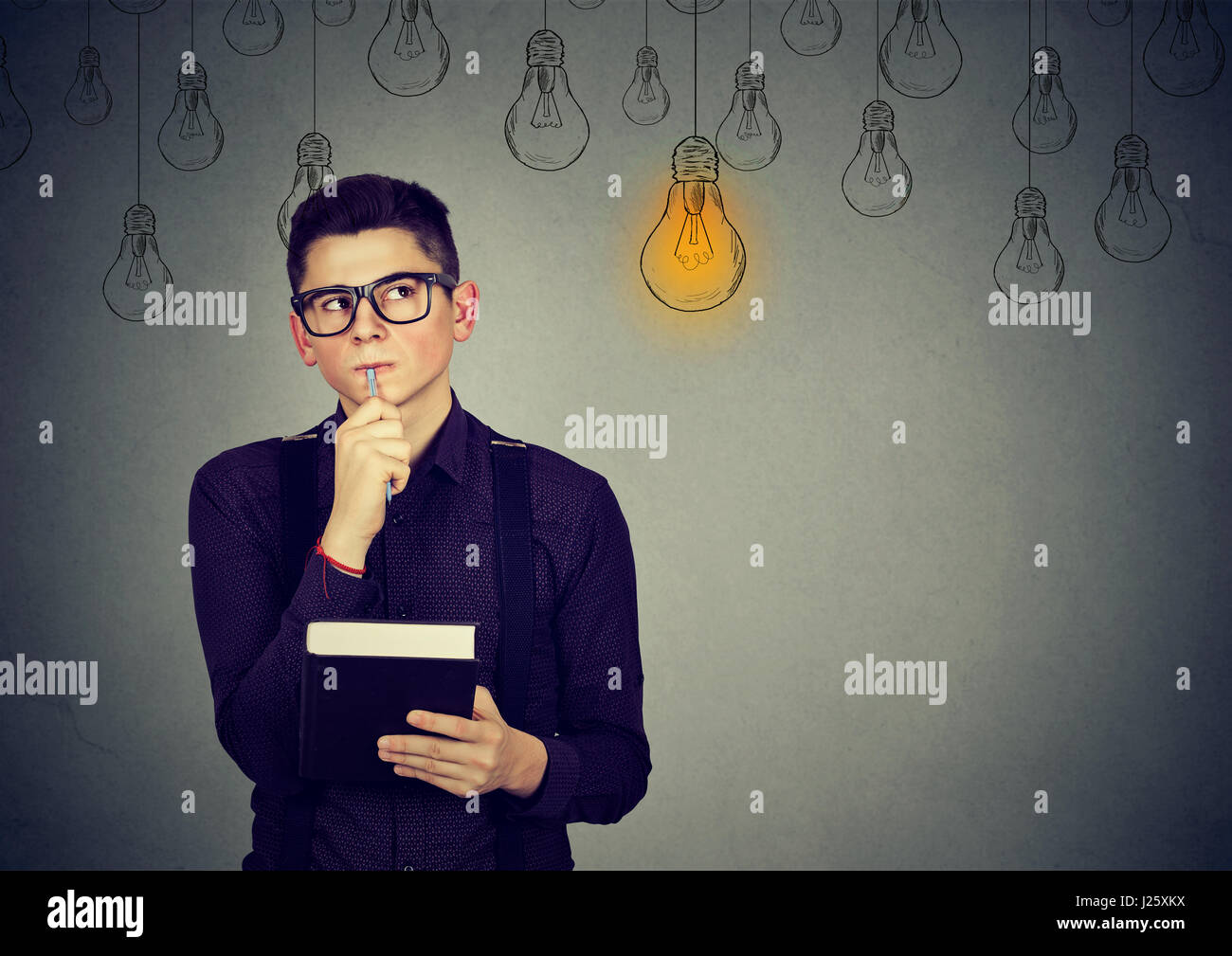 Handsome thinking man in glasses looking up with light idea bulb above ...