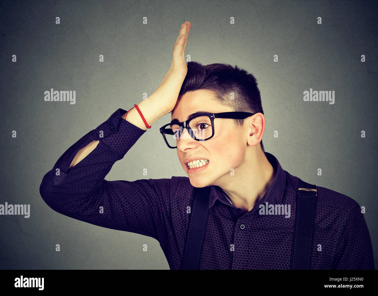 Regrets wrong doing. Silly young man, slapping hand on head having duh ...