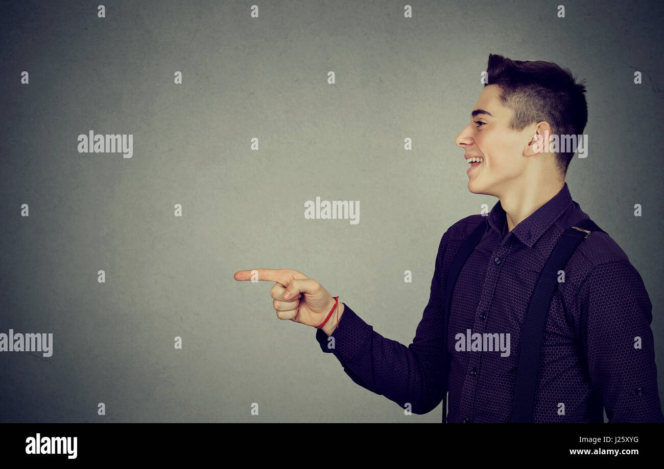 Side profile of a happy man pointing finger at something isolated on ...