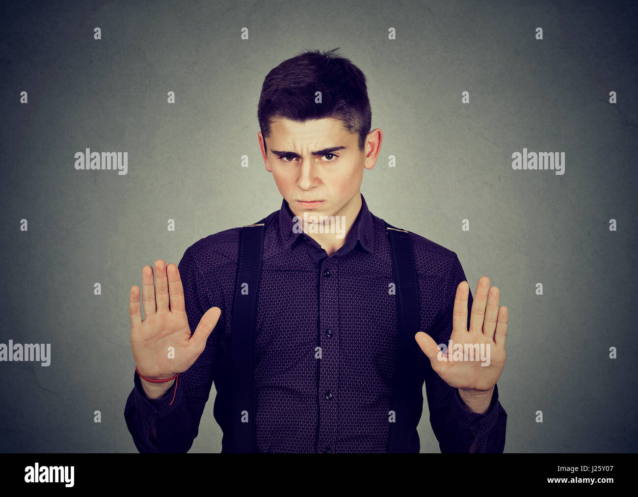 angry young guy showing stop hand gesture Stock Photo - Alamy